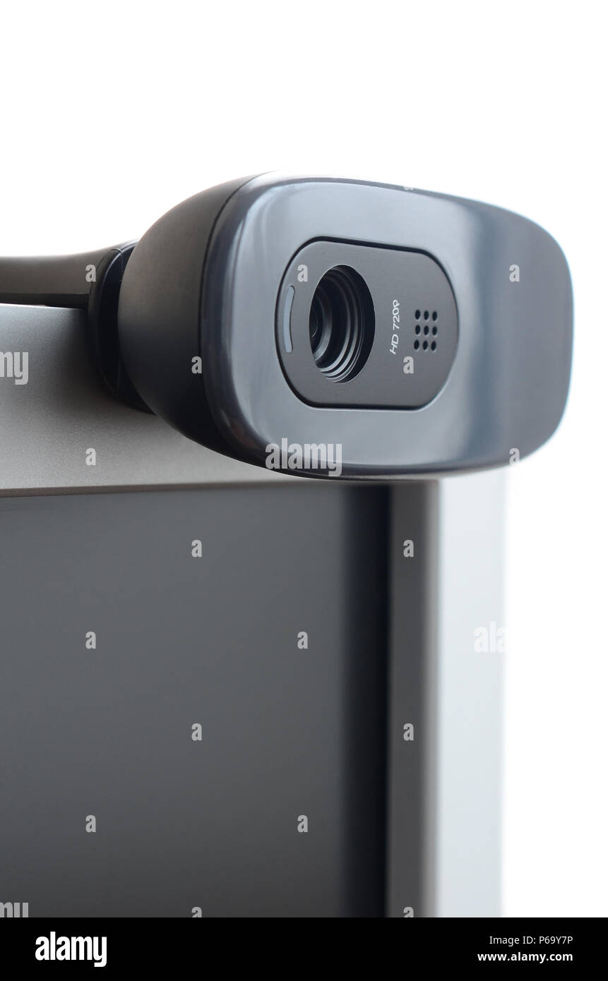A modern web camera is installed on the body of a flat screen monitor ...