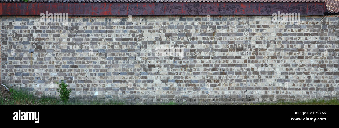 The texture of the warehouse wall from a variety of rough stones of ...