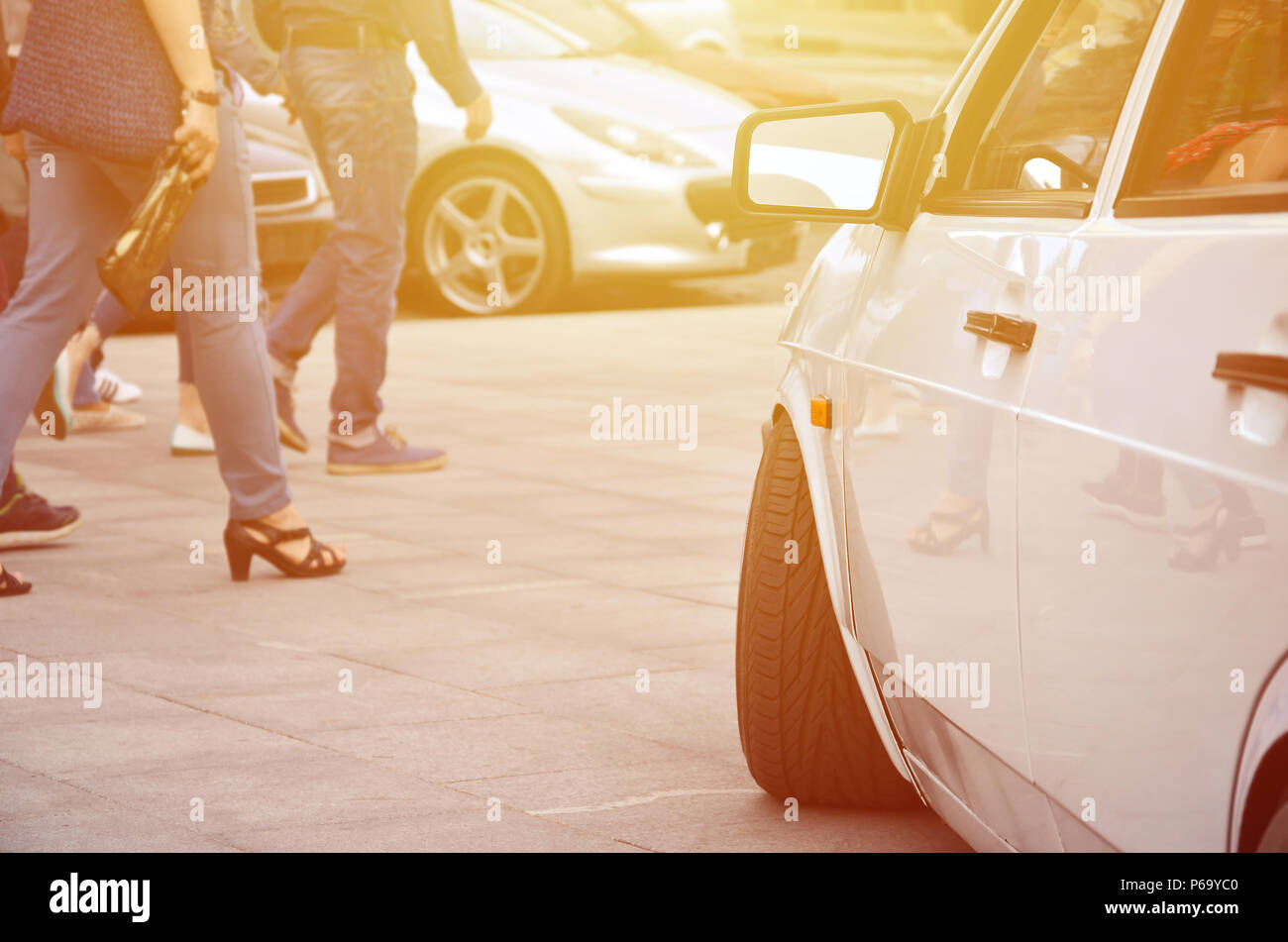 Diagonal view of a white glossy car that stands on a square of gray ...