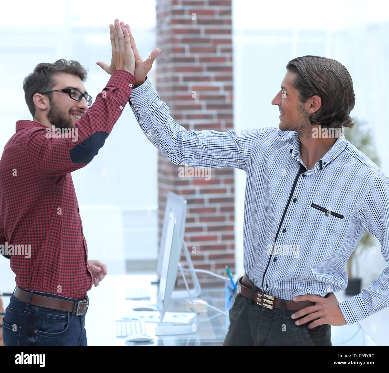 two colleagues giving each other high-five Stock Photo - Alamy