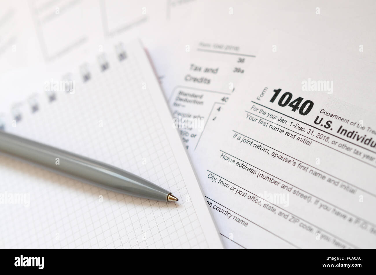 The pen and notebook is lies on the tax form 1040 U.S. Individual ...