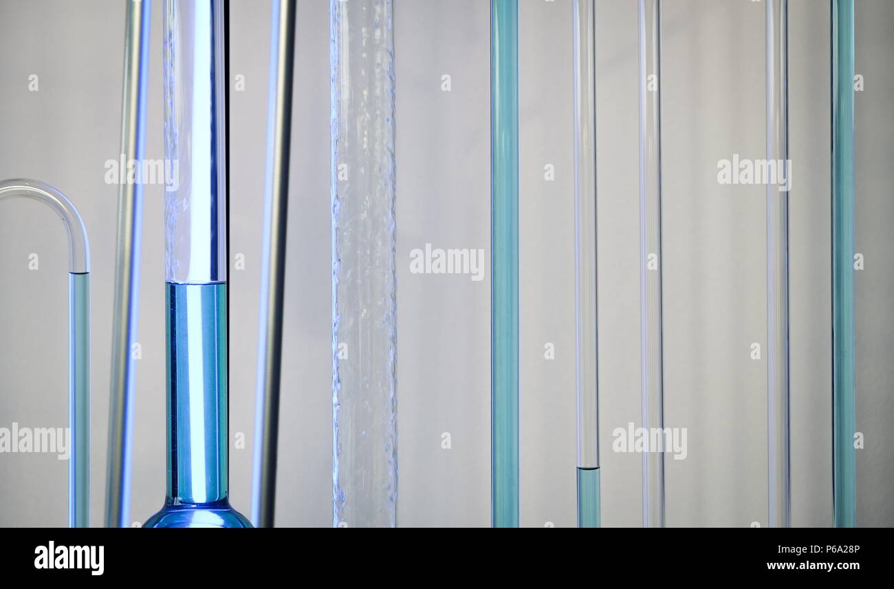 Glass pipes with blue liquid acting as a fluid clock Stock Photo - Alamy