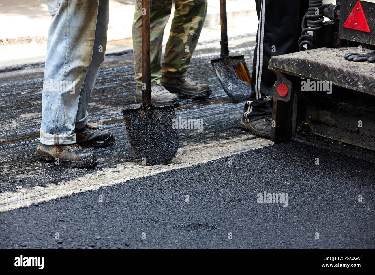 Workers using asphalt paver tools during road construction Stock Photo ...