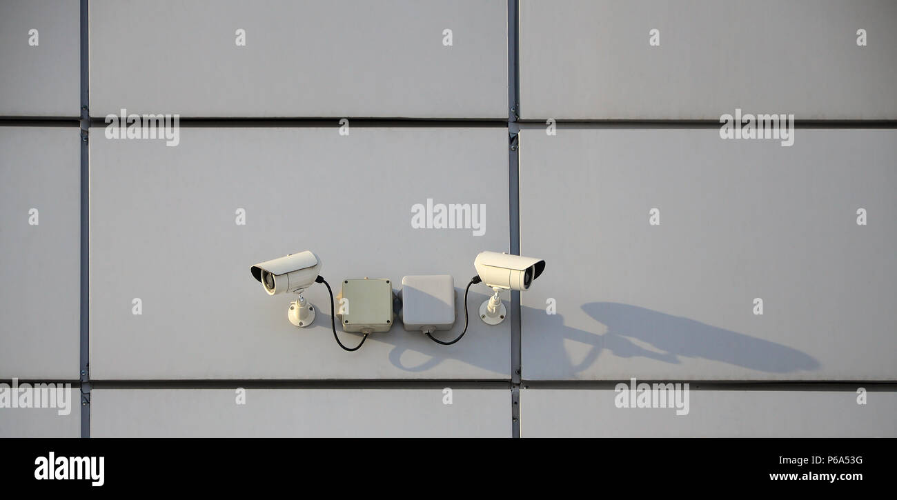 White surveillance camera built into the metal wall of the office ...