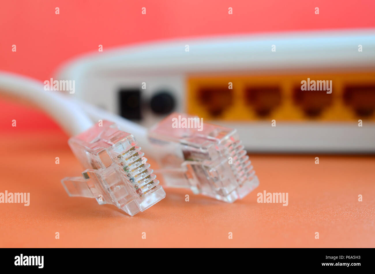 Internet router and Internet cable plugs lie on a bright orange ...