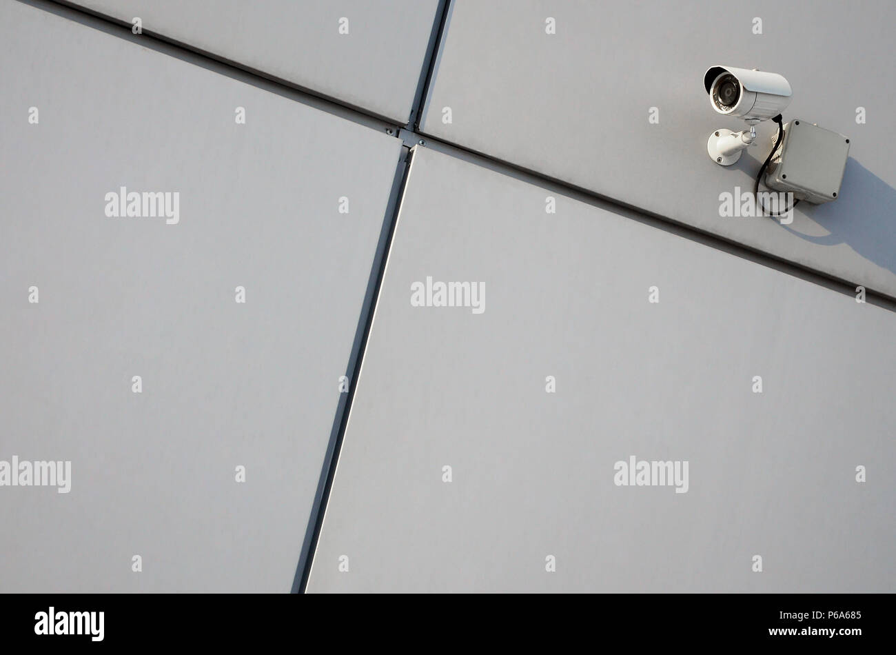 White surveillance camera built into the metal wall of the office ...