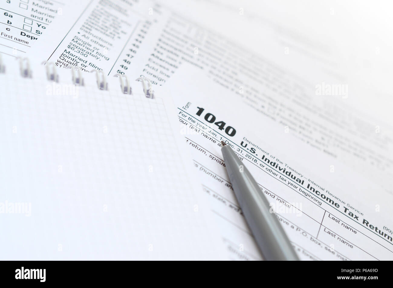 The pen and notebook is lies on the tax form 1040 U.S. Individual ...