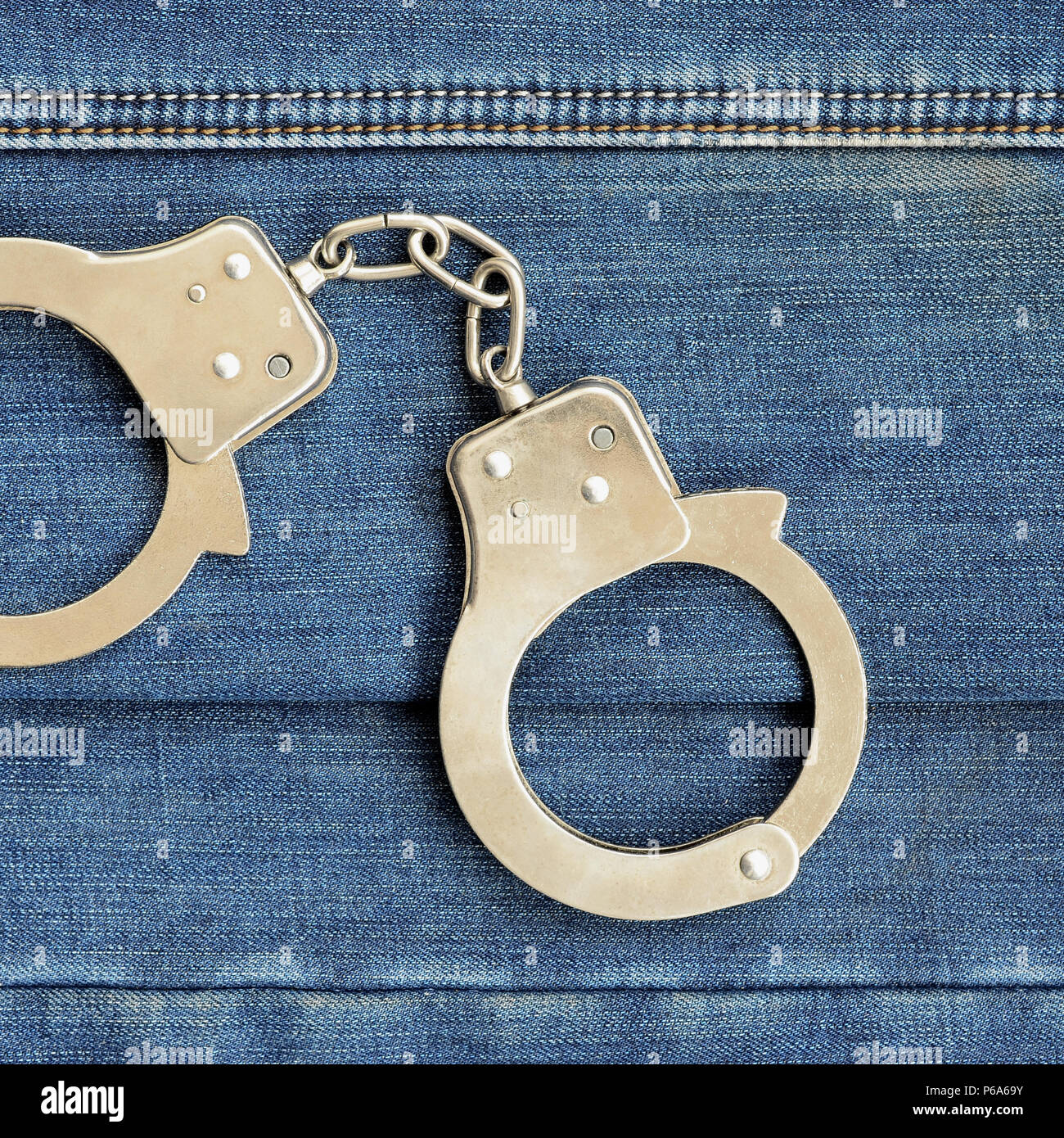 Police steel handcuffs lying on dark blue jeans background Stock Photo ...