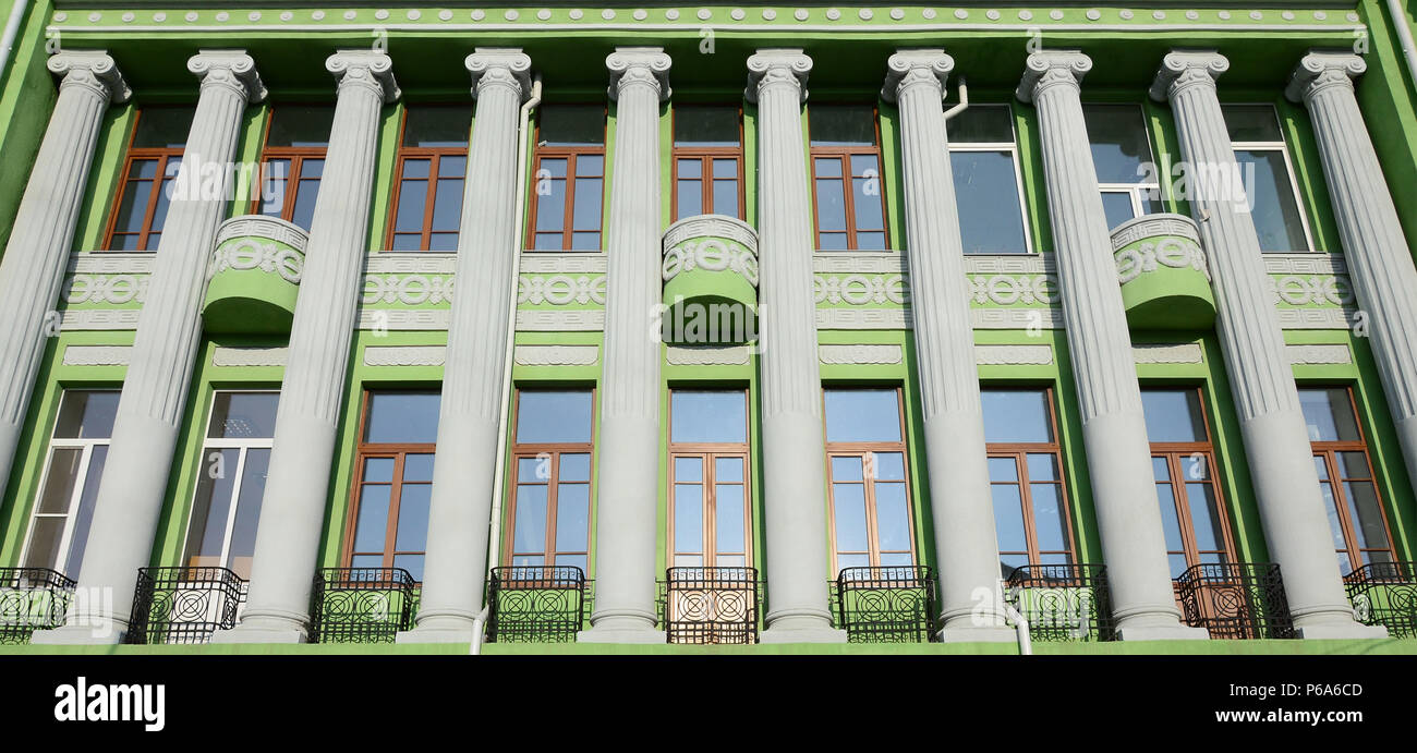 Restored old multi-storey building with antique columns, painted in ...
