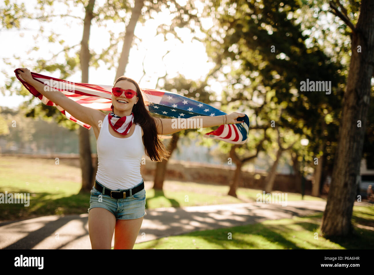 Portrait of patriotic american woman running with national flag in the ...