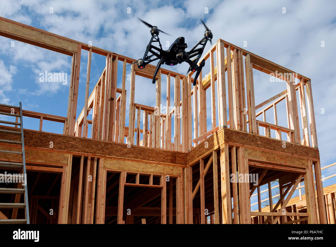 Black drone quadcopter with camera flying over residential construction ...