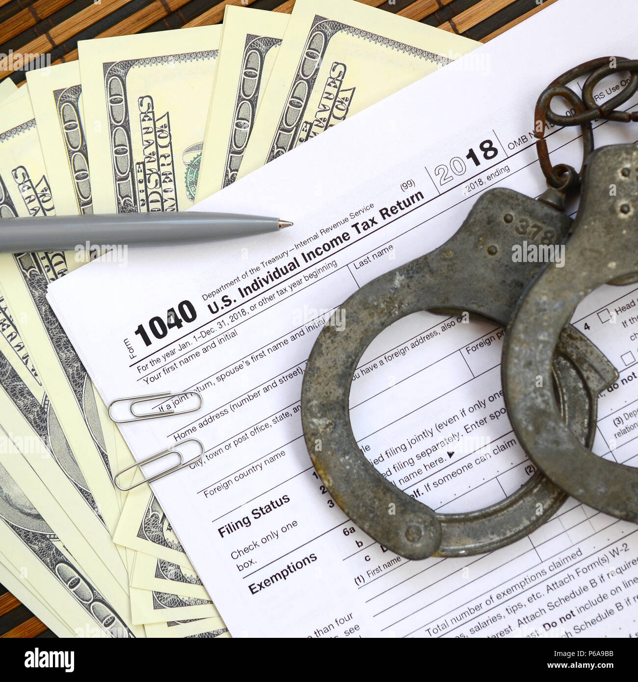 Police handcuffs lie on the tax form 1040. The concept of problems with ...