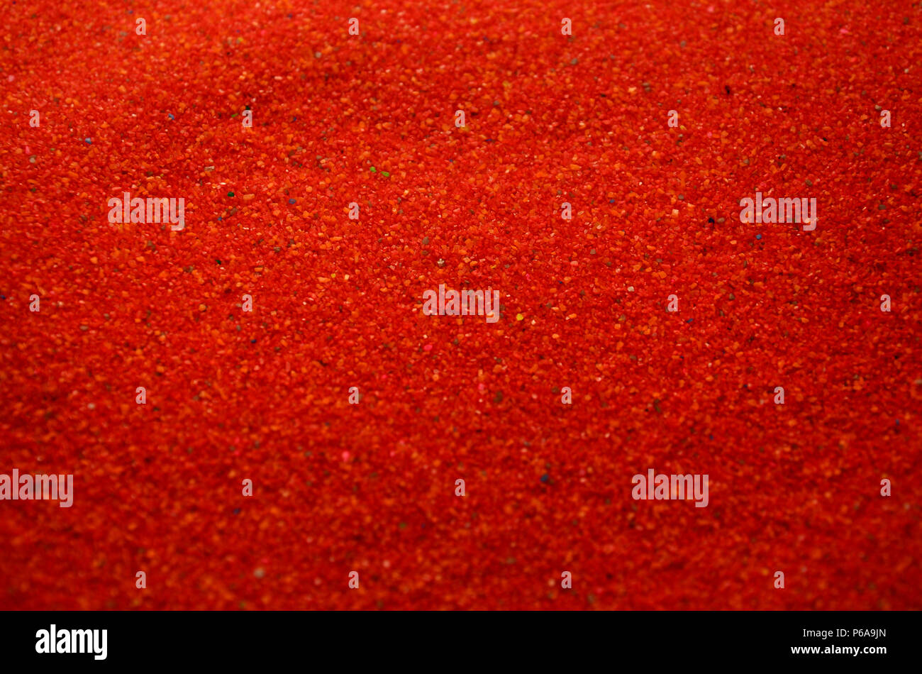 Texture of a colored granular sand close up. Red grains Stock Photo - Alamy