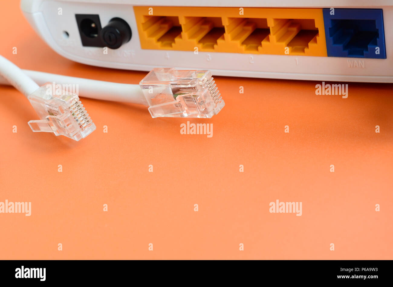 Internet router and Internet cable plugs lie on a bright orange ...