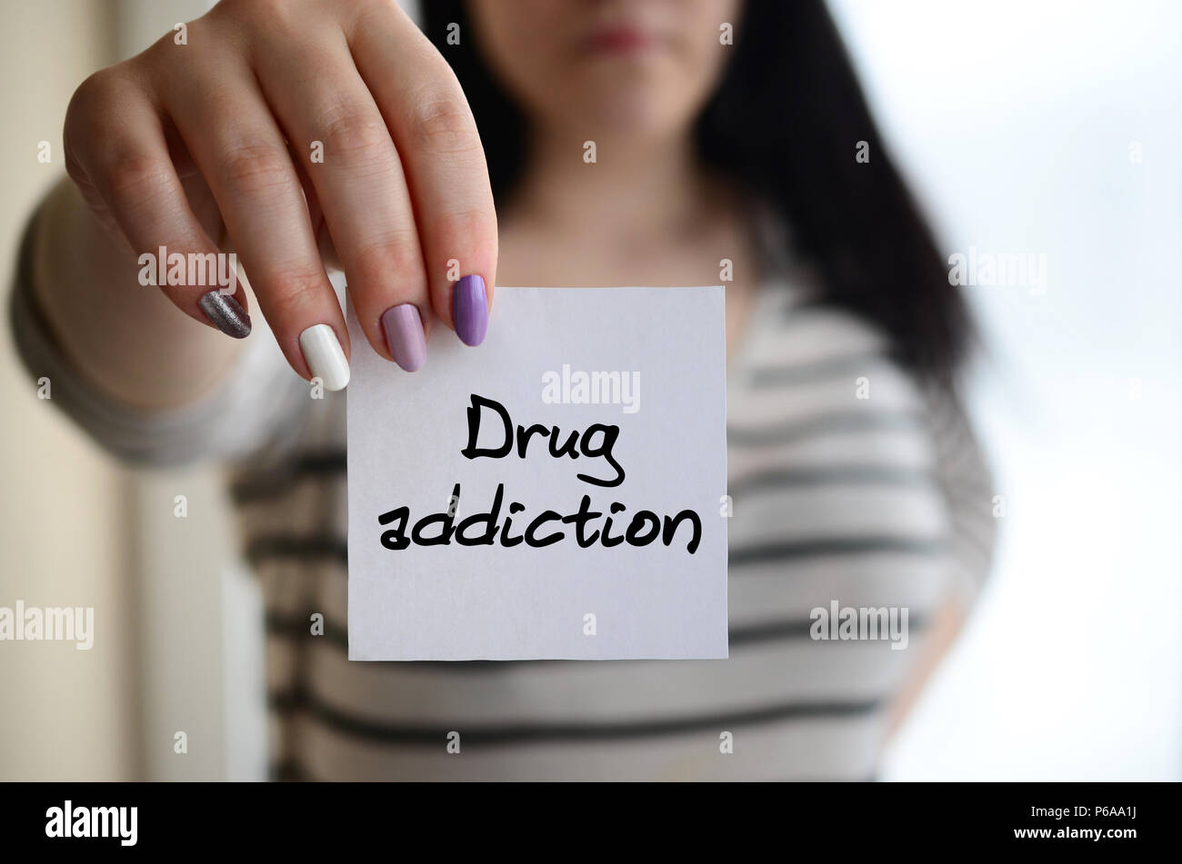 Young sad girl shows a white sticker. Caucasian brunette holding a ...