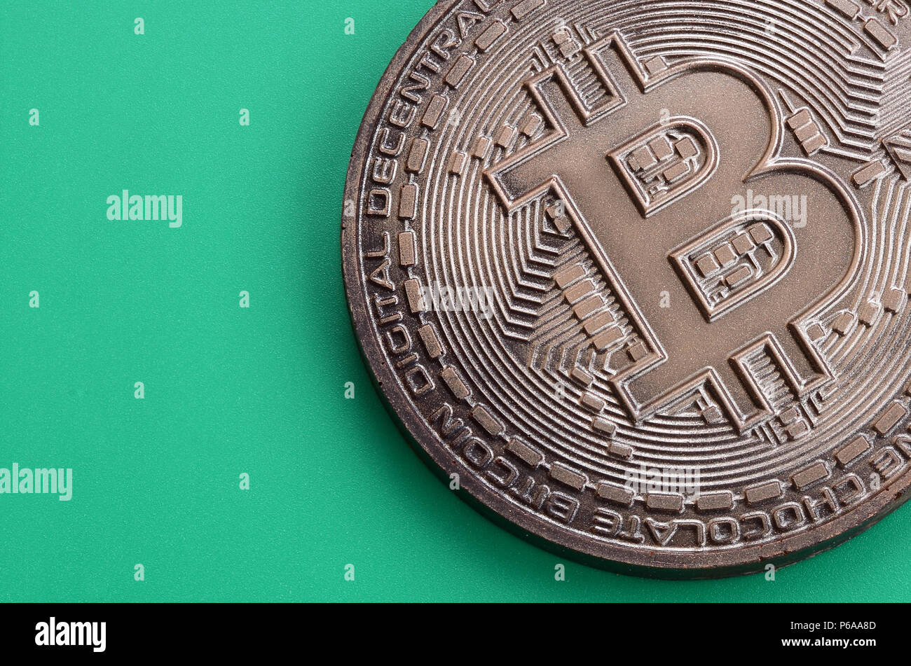 Chocolate product in the form of physical bitcoin lies on a green ...