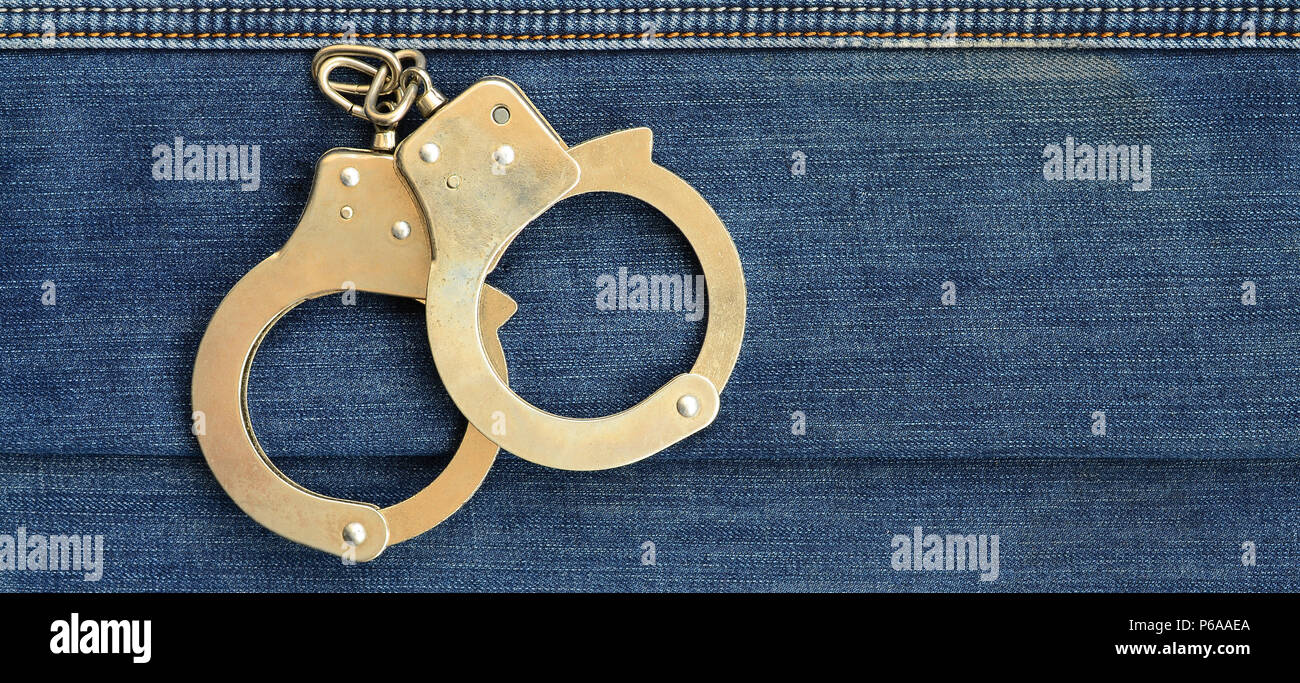 Police steel handcuffs lying on dark blue jeans background Stock Photo ...