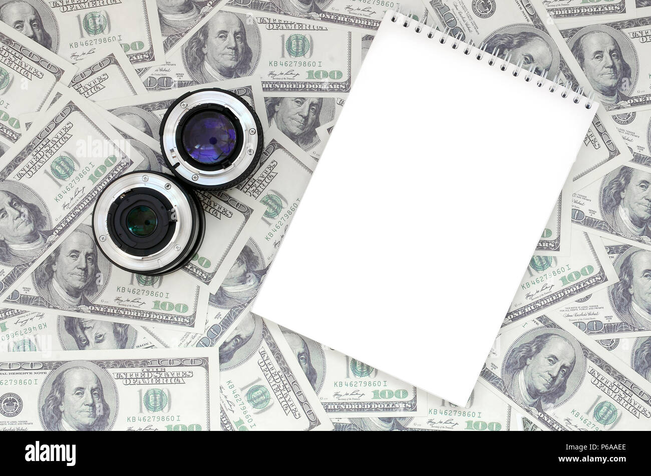 Two photographic lenses and white notebook lie on the background of a ...