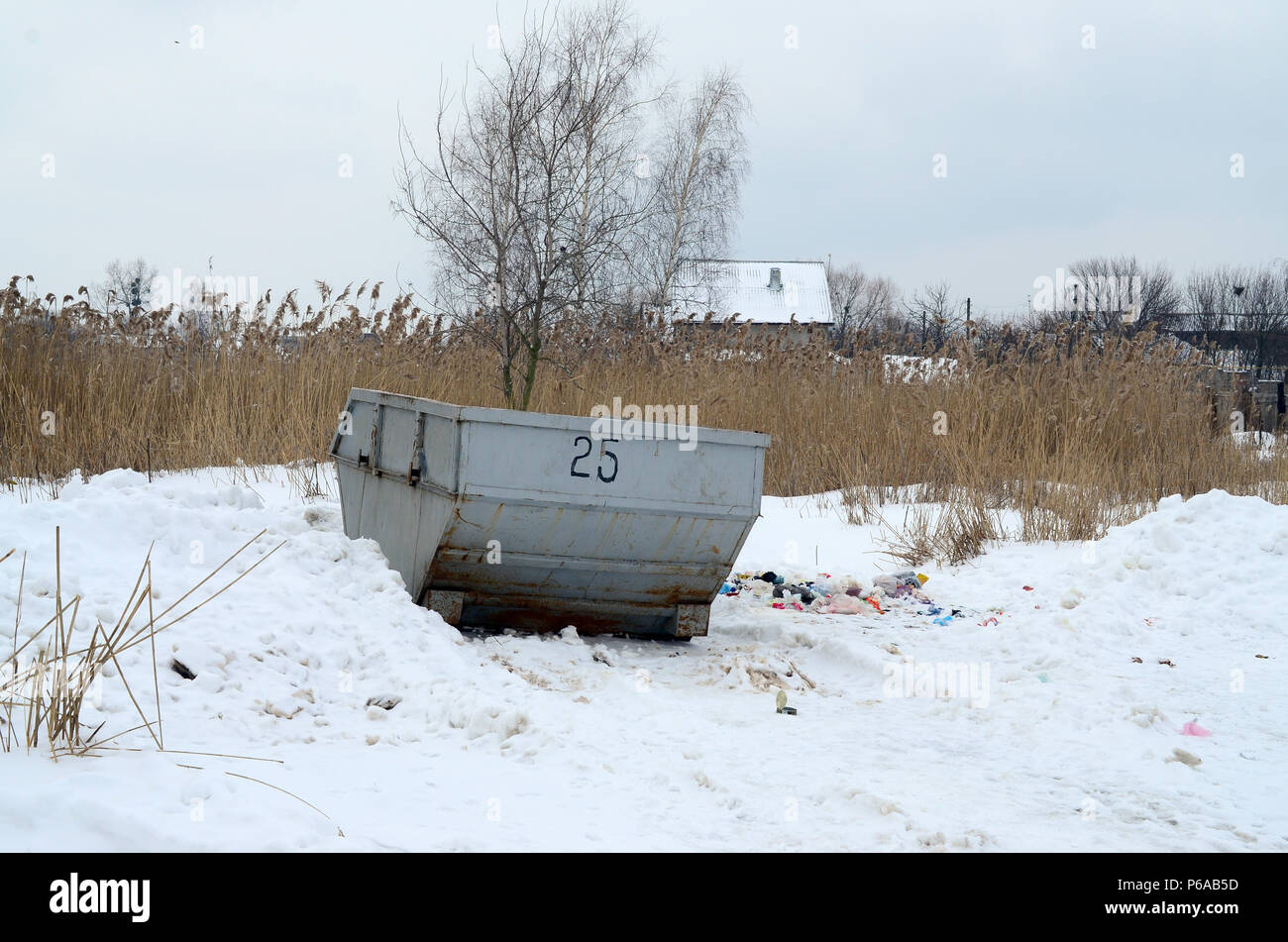 Trash bin at the side of street in winter with lip garbage container ...