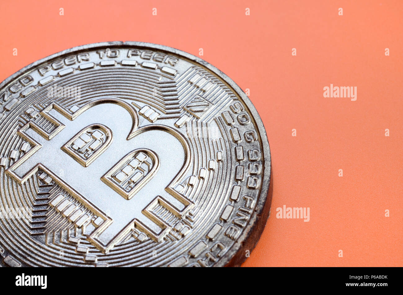 Chocolate product in the form of physical bitcoin lies on an orange ...