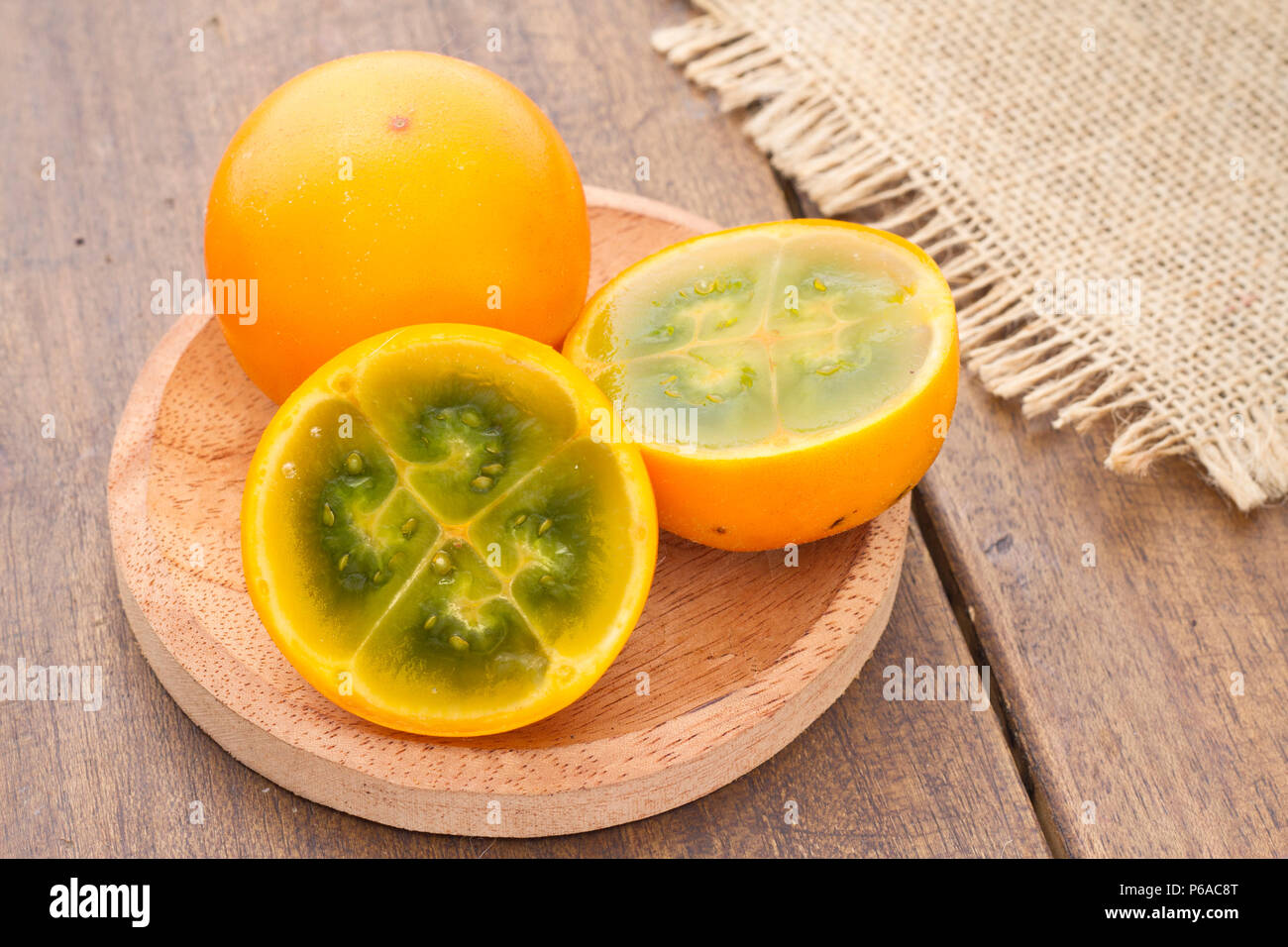 Fruits and slices of lulo or naranjilla on the wooden table - Solanum ...