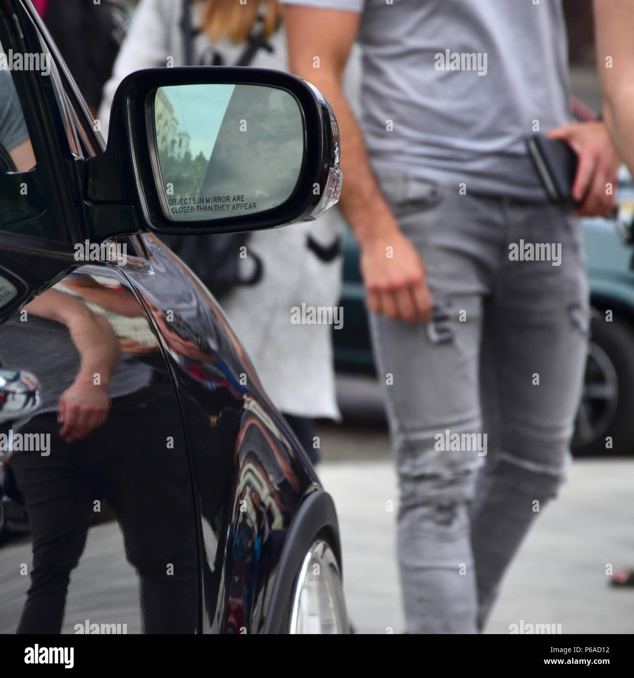 Diagonal view of a black glossy car with white wheels, which stands on ...