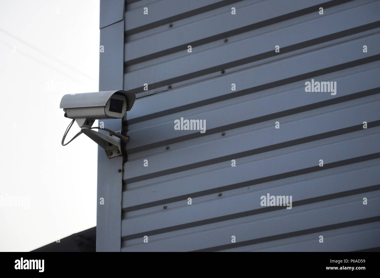 White surveillance camera built into the metal wall of the office ...