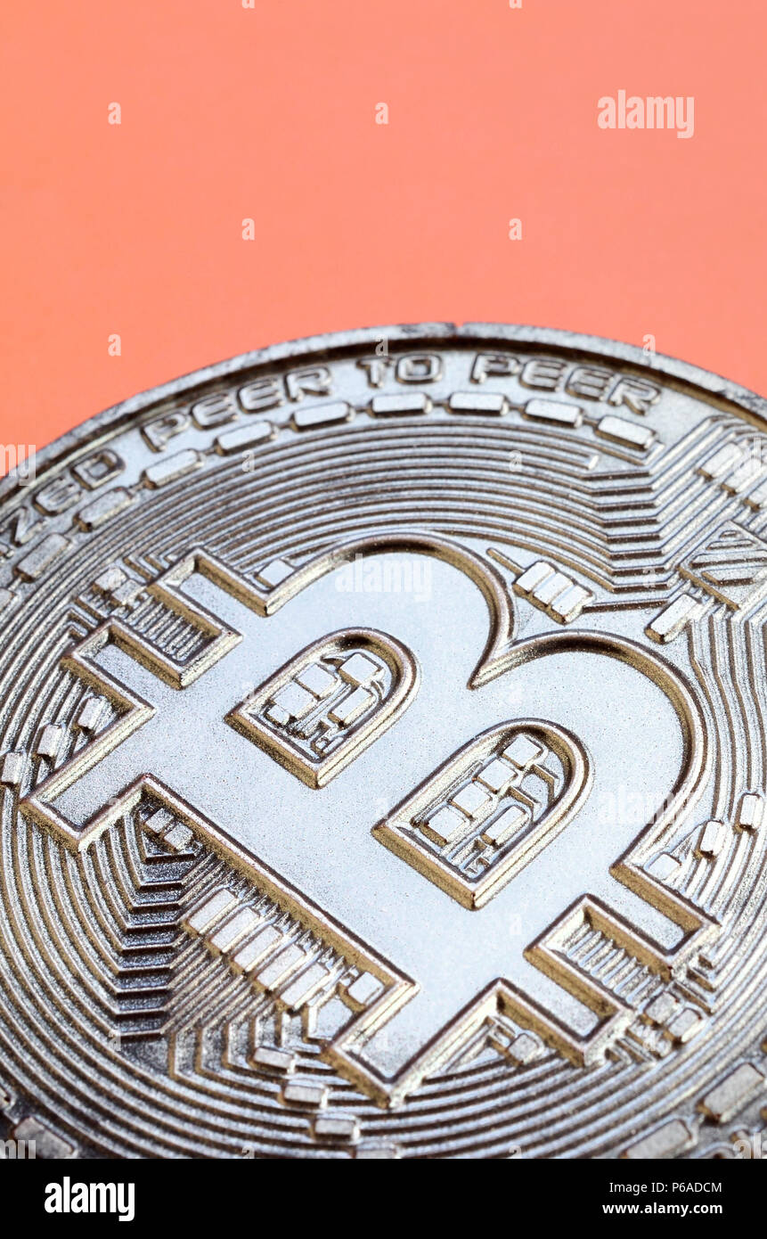 Chocolate product in the form of physical bitcoin lies on an orange ...