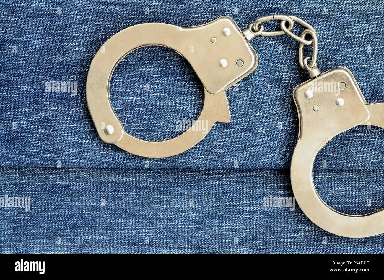 Police steel handcuffs lying on dark blue jeans background Stock Photo ...