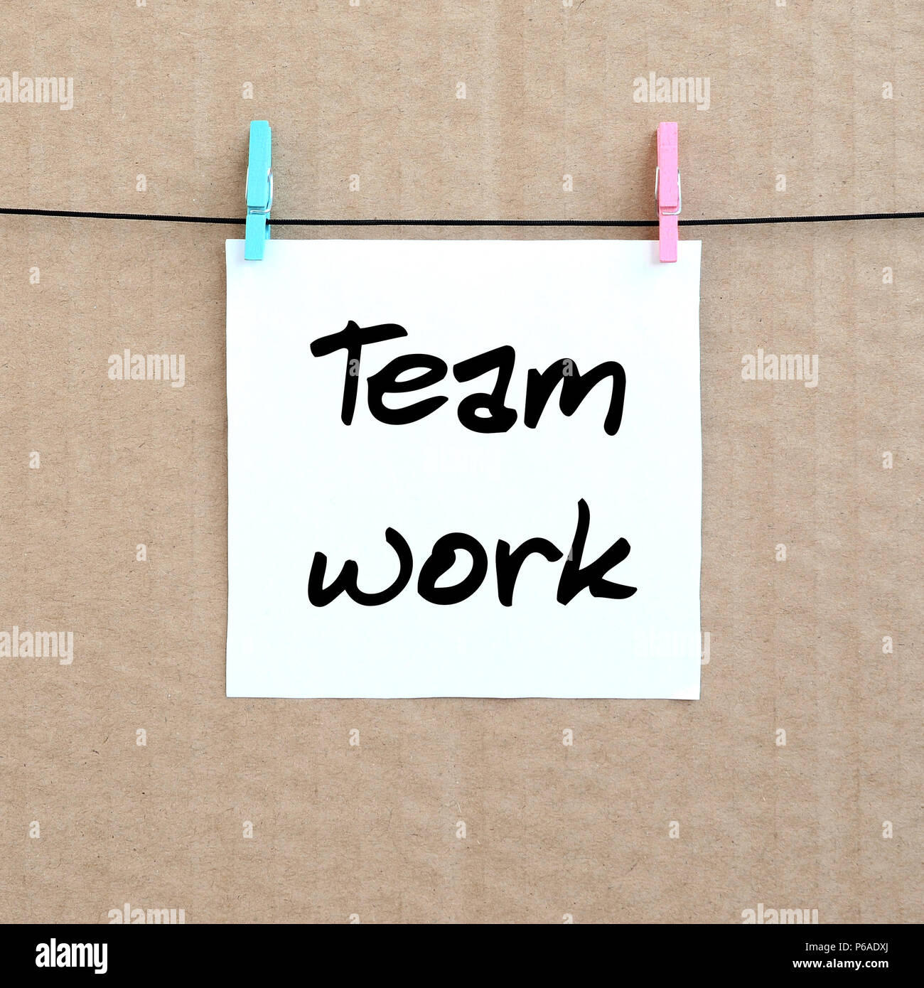Team work. Note is written on a white sticker that hangs with a ...