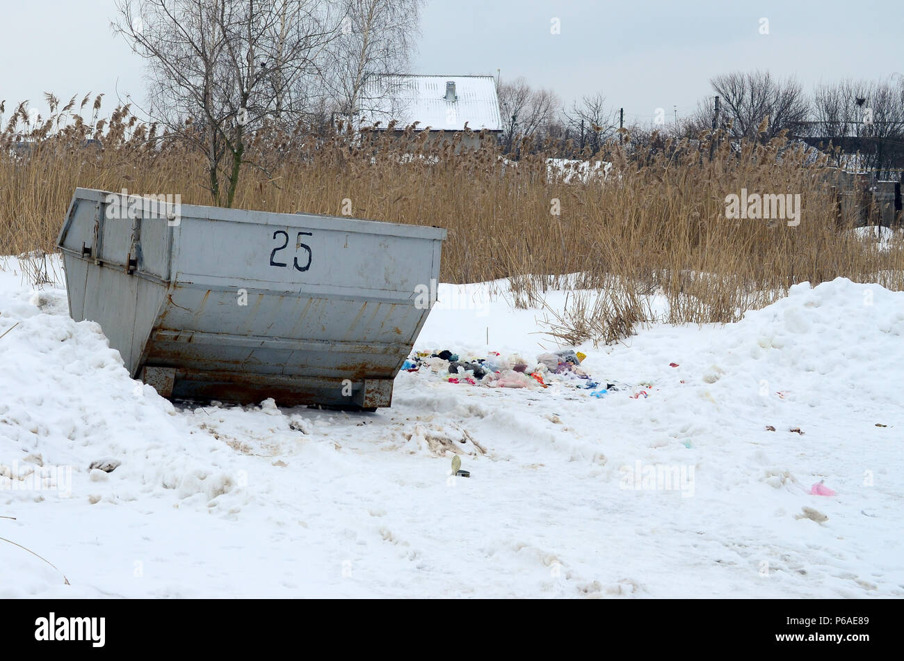 Trash bin at the side of street in winter with lip garbage container ...
