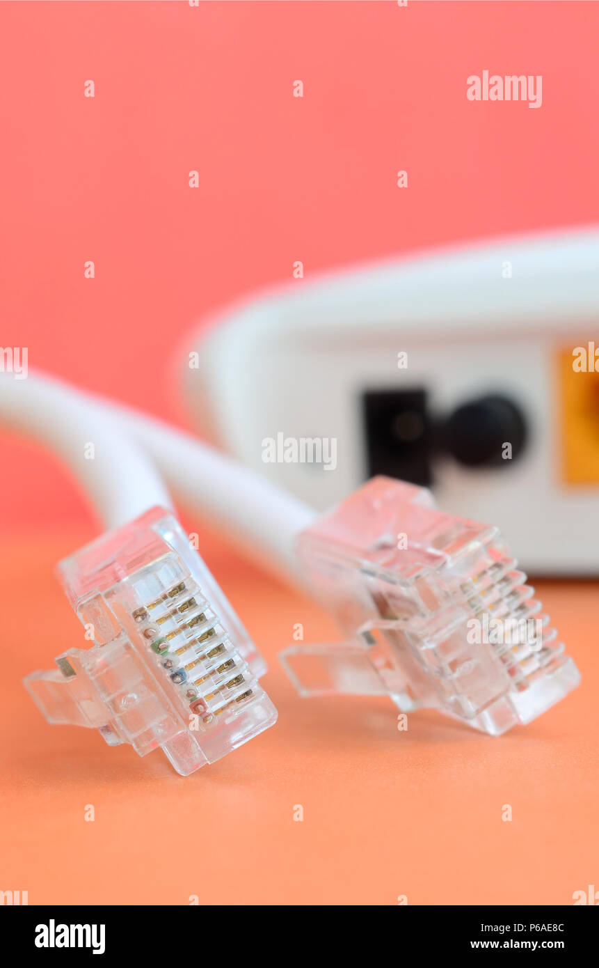 Internet router and Internet cable plugs lie on a bright orange ...