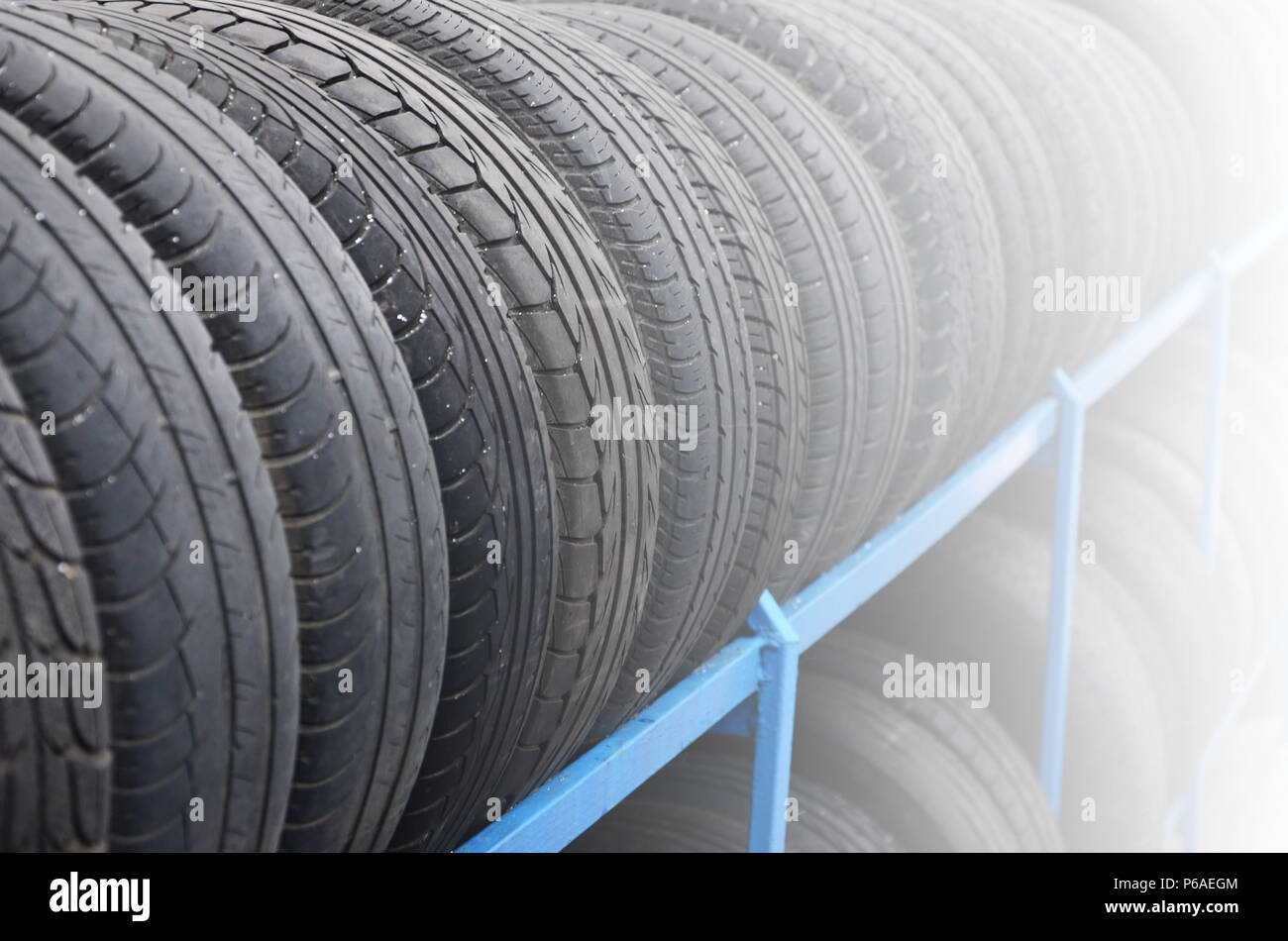 Rack with variety of car tires in automobile store. Many black tires ...