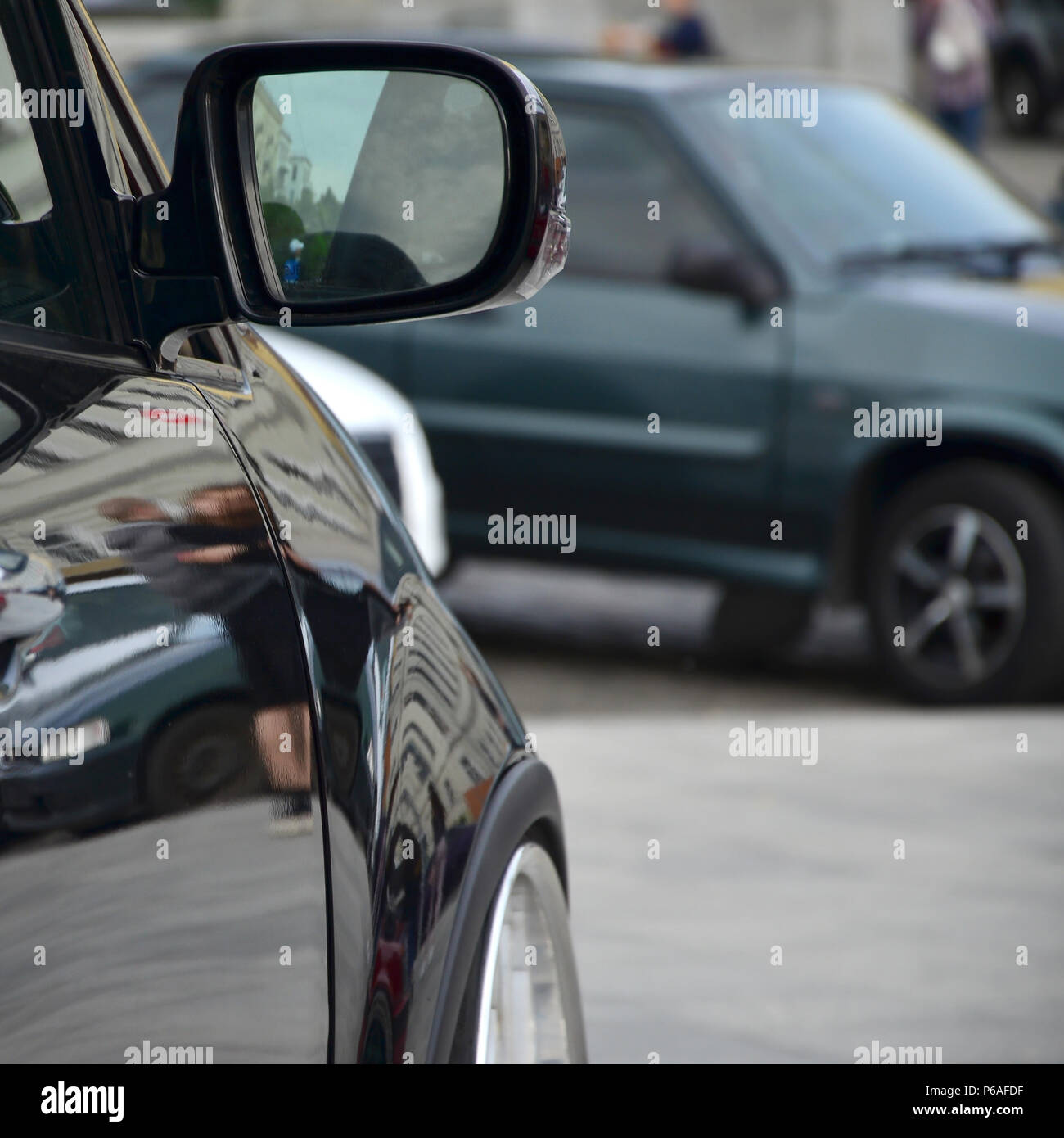 Diagonal view of a black glossy car with white wheels, which stands on ...