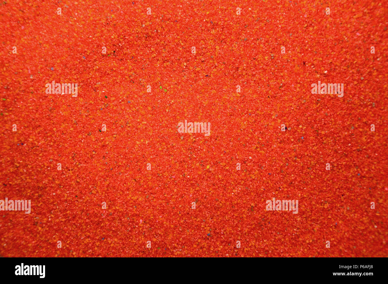Texture of a colored granular sand close up. Red grains Stock Photo - Alamy