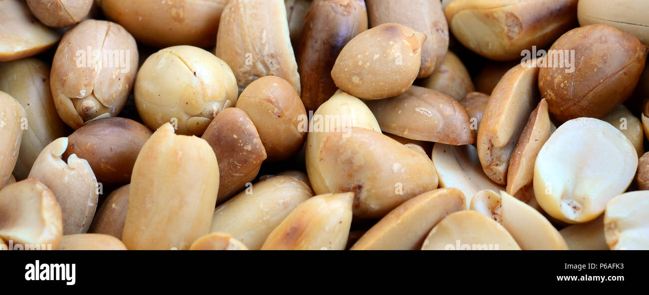 Peanut. A lot of small yellow nuts without peel. Background texture ...