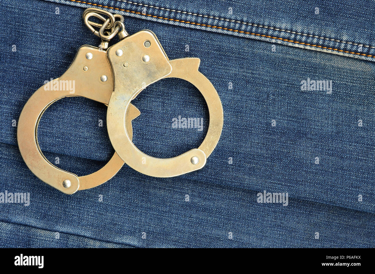 Police steel handcuffs lying on dark blue jeans background Stock Photo ...