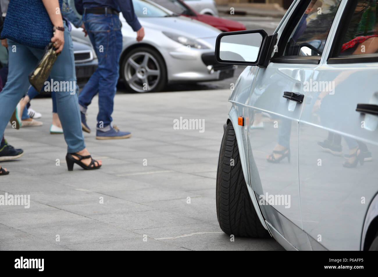 Diagonal view of a white glossy car that stands on a square of gray ...
