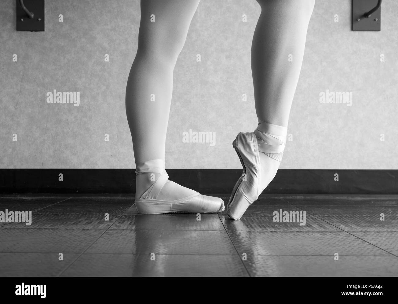 Black and white version of ballet dancer warming up her feet in her ...