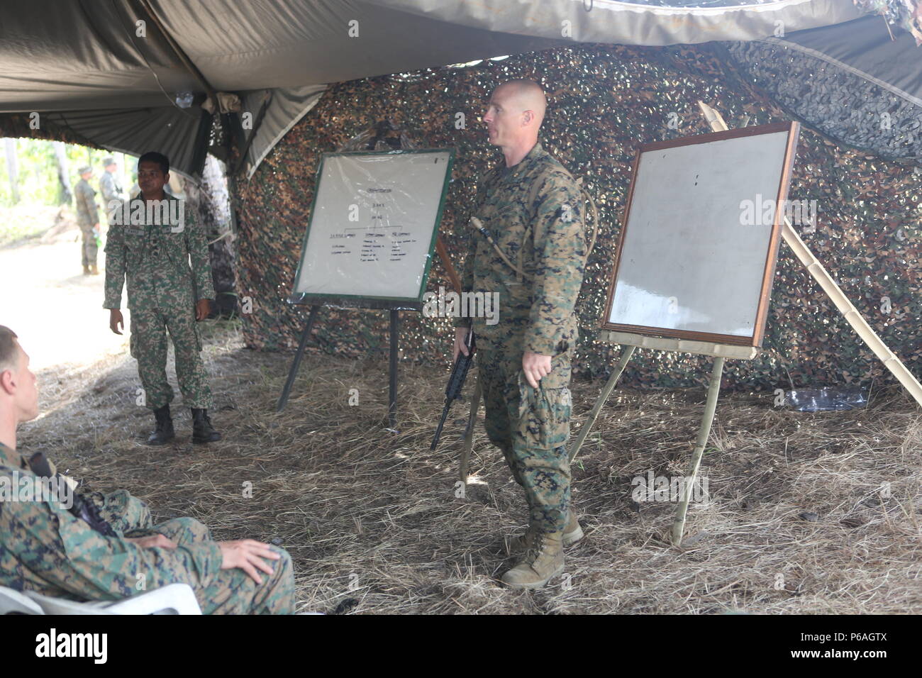 A Royal Malay Regiment officer and a U.S. Marine Corps officer confer ...