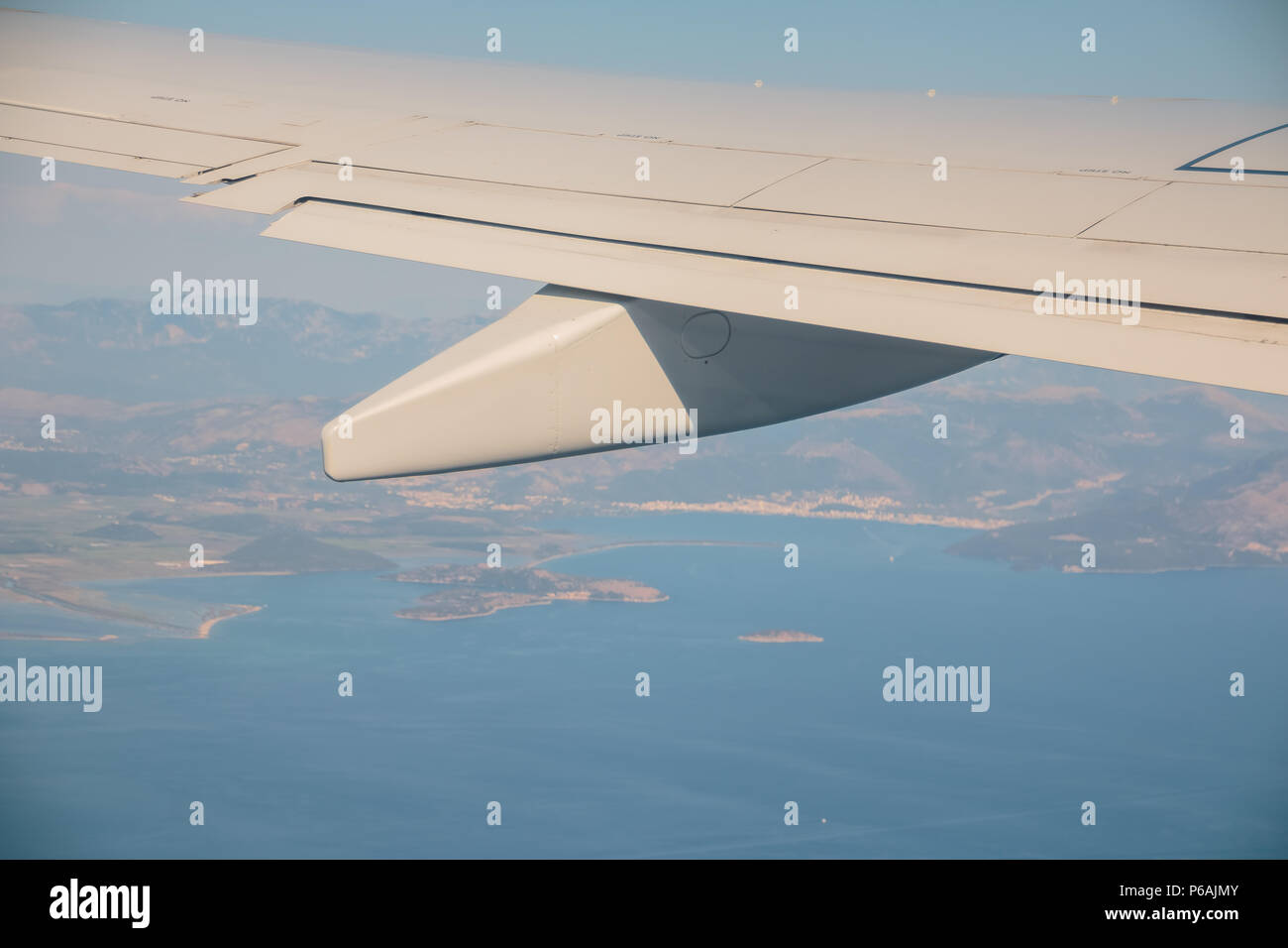 The sea and the island looked out of the plane window with wing ...