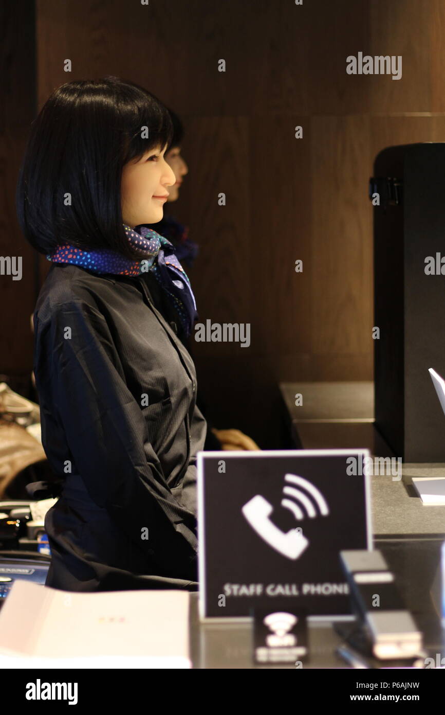 A pair of robot receptionist working on the reception desk of a Henn na ...