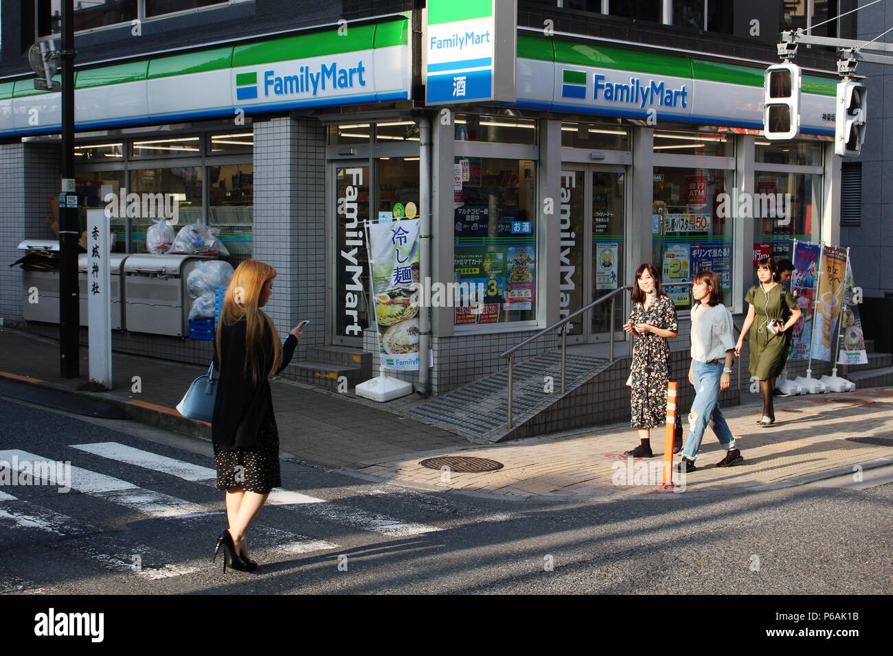 A FamilyMart convenience store on the corner of a street in the hilly ...