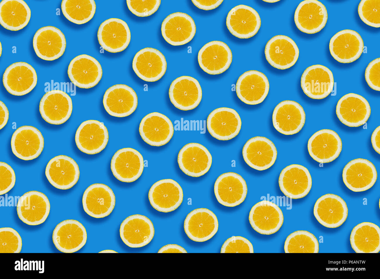 lemon pattern. yellow lemons slices on blue paper background, trendy ...