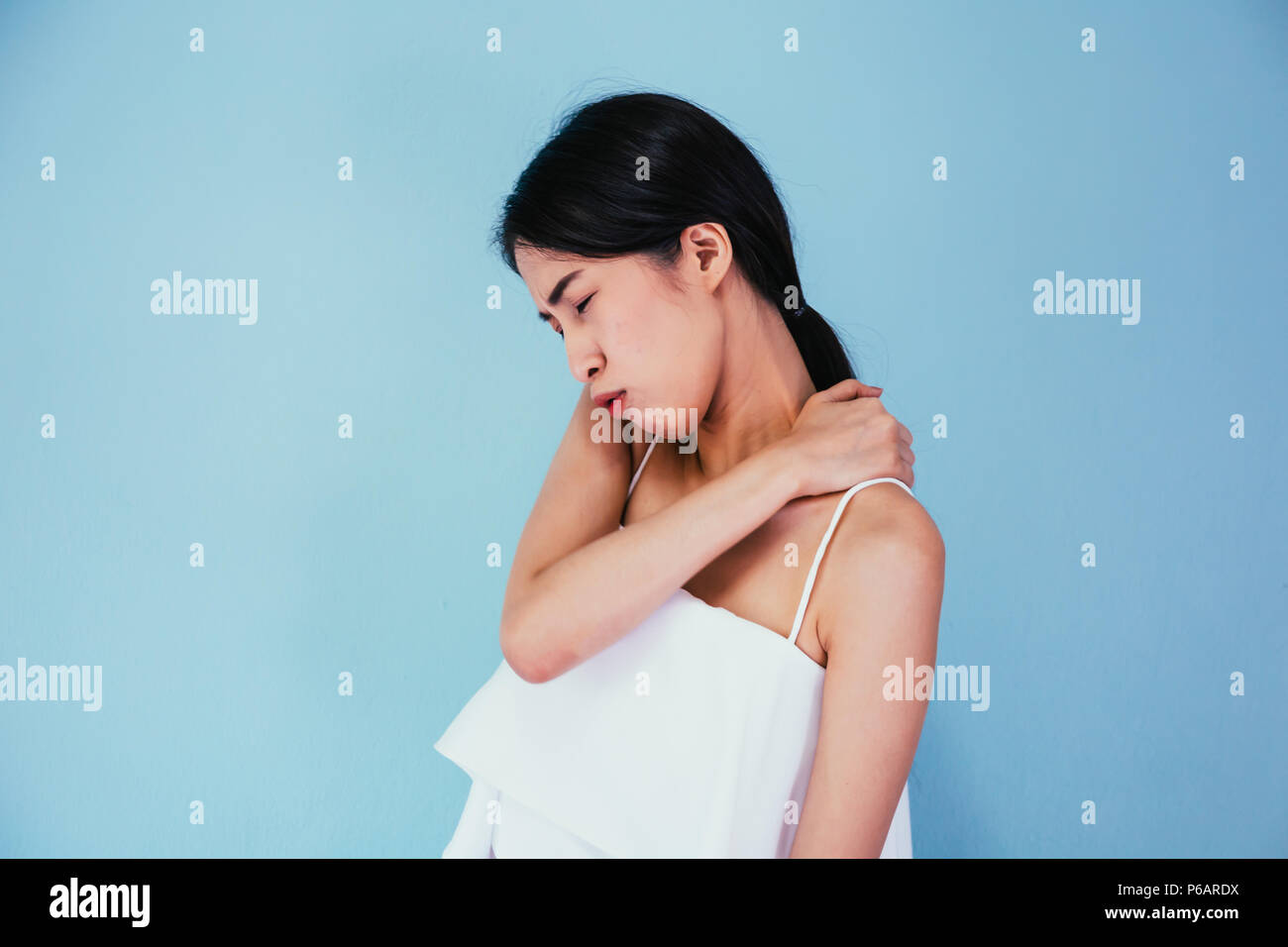Young Asian woman having chronic neck and shoulder pain isolated over ...