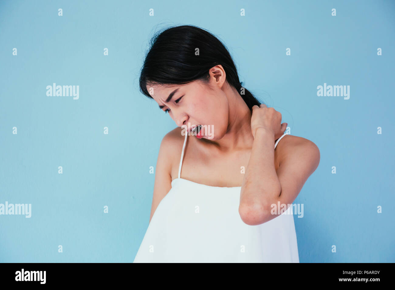 Young Asian woman having chronic neck and shoulder pain isolated over ...
