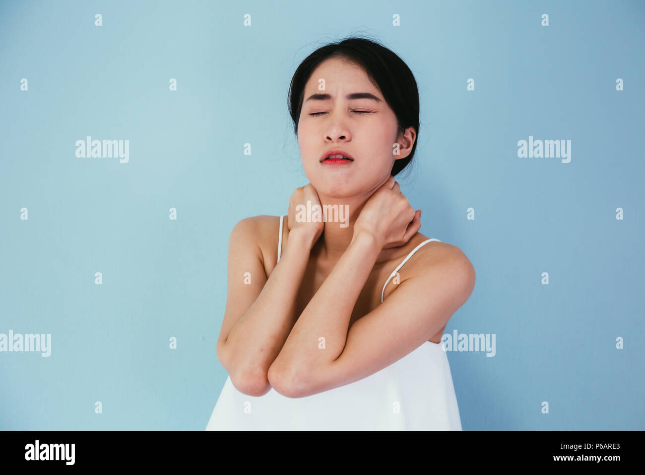 Young Asian woman having chronic neck and shoulder pain isolated over ...