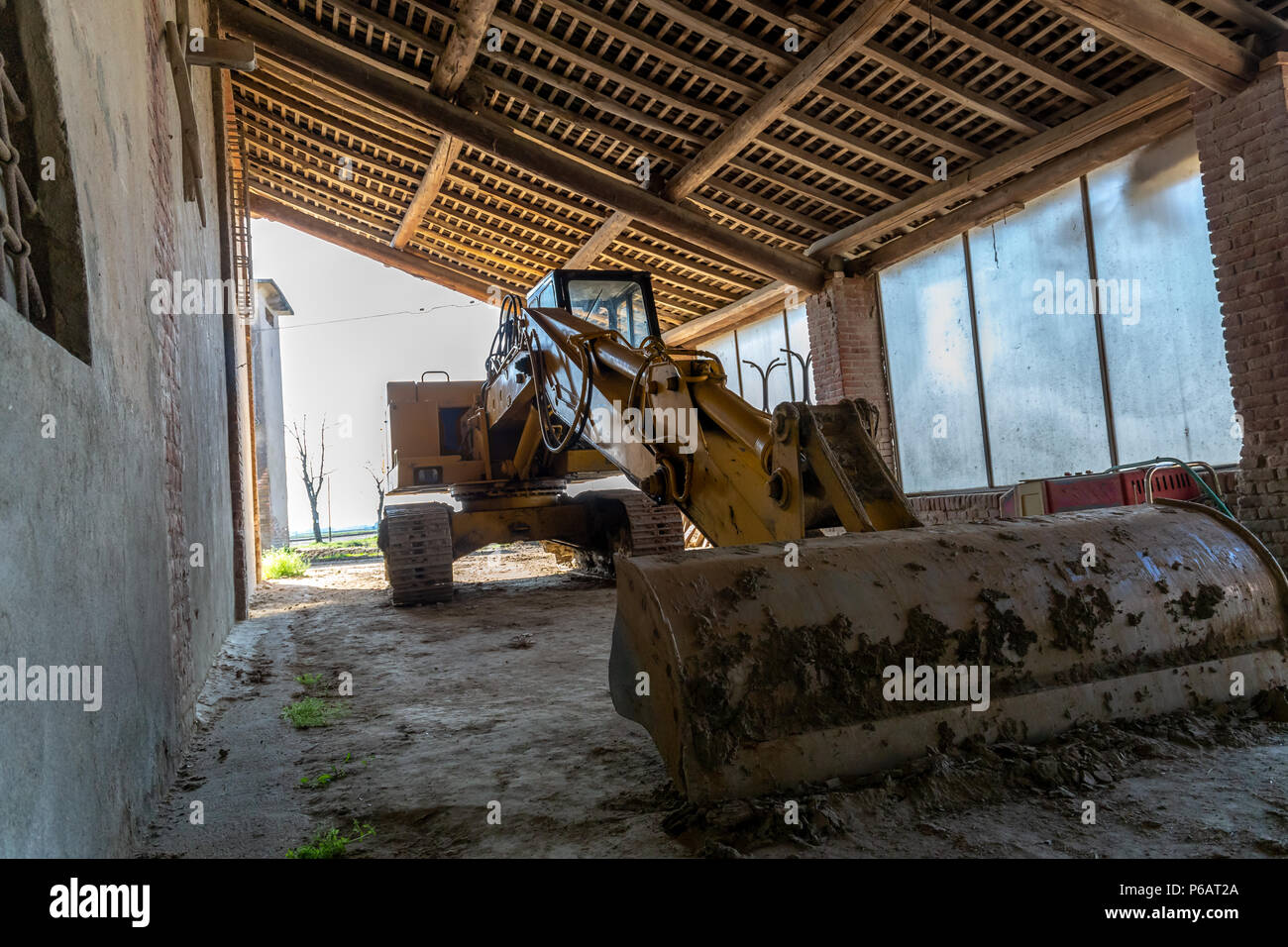 photograph of a bulldozer parked under a farm shed Stock Photo - Alamy