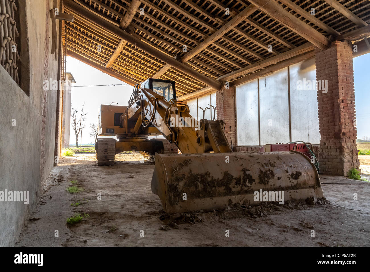 photograph of a bulldozer parked under a farm shed Stock Photo - Alamy