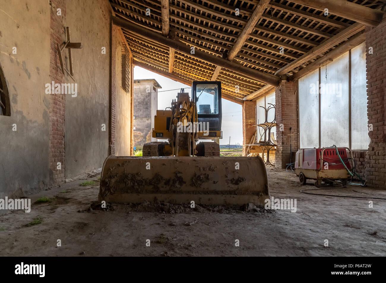 photograph of a bulldozer parked under a farm shed Stock Photo - Alamy